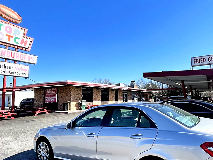 That iconic neon sign isn't just advertising—it's a time machine to when drive-ins ruled and burgers were an event, not just a meal.