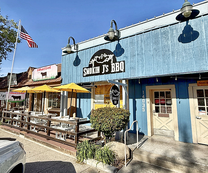 The blue facade of Smokin J's BBQ stands out like a beacon of hope for hungry travelers. Yellow umbrellas promise sunny dining alongside serious smoking.