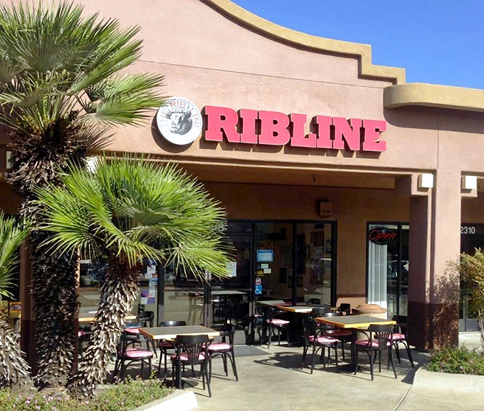 The unassuming storefront that launches a thousand food pilgrimages. Palm trees stand guard outside this temple of barbecue, as if whispering, "Prepare your napkins."