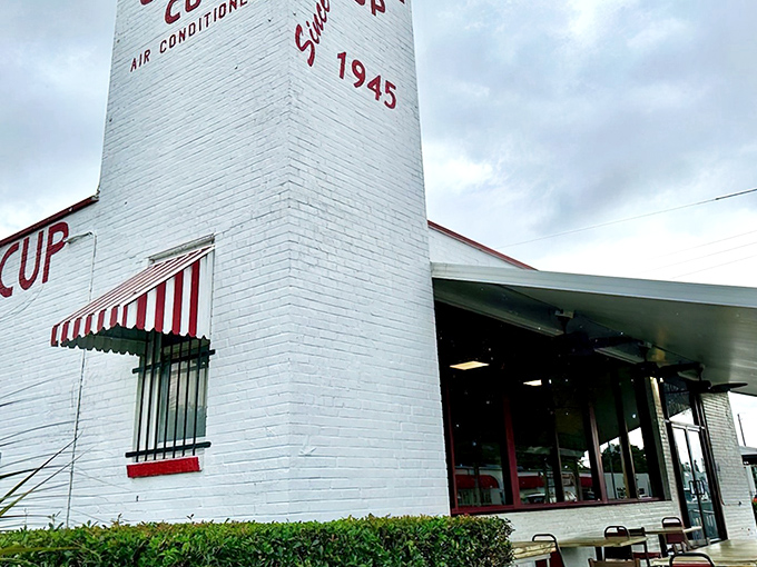 The white brick exterior with its classic red awning isn't trying to be retro &ndash; it's the real deal, standing proudly since 1945 in Pensacola's morning landscape.
