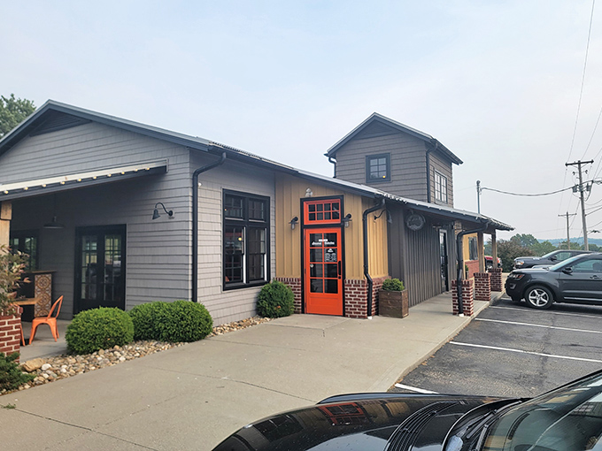 The bright orange door beckons like a pizza portal to paradise, promising delicious adventures within this charming Sugarcreek establishment.