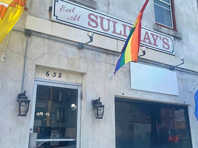 The unassuming facade of Sulimay's welcomes you with its vintage sign and rainbow flag, promising both tradition and inclusivity in Philadelphia's evolving Fishtown neighborhood.