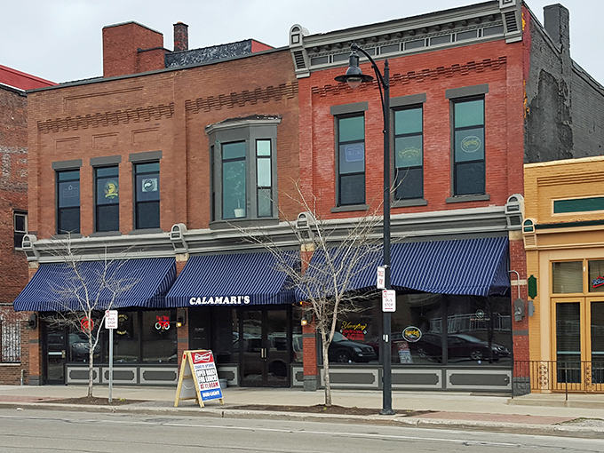 The historic brick fa&ccedil;ade of Calamari's Squid Row stands proudly on Erie's streetscape, its blue awnings beckoning hungry travelers like maritime flags.