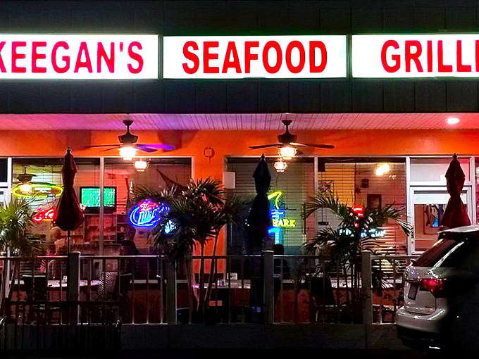 Keegan's iconic neon sign glows like a beacon for seafood pilgrims, promising Florida's finest grouper sandwiches behind those unassuming doors.