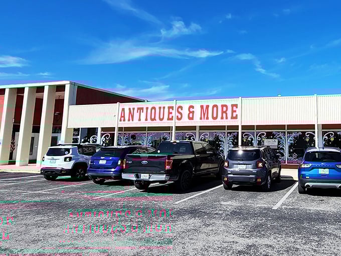 The unassuming exterior belies the treasure trove within. Like a time-travel portal disguised as a strip mall storefront, Wildwood beckons with its simple "ANTIQUES & MORE" promise. 