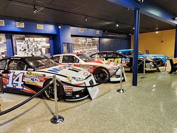 Racing history frozen in time. The iconic #14 car gleams under museum lighting, surrounded by its high-octane neighbors in this motorsport sanctuary.