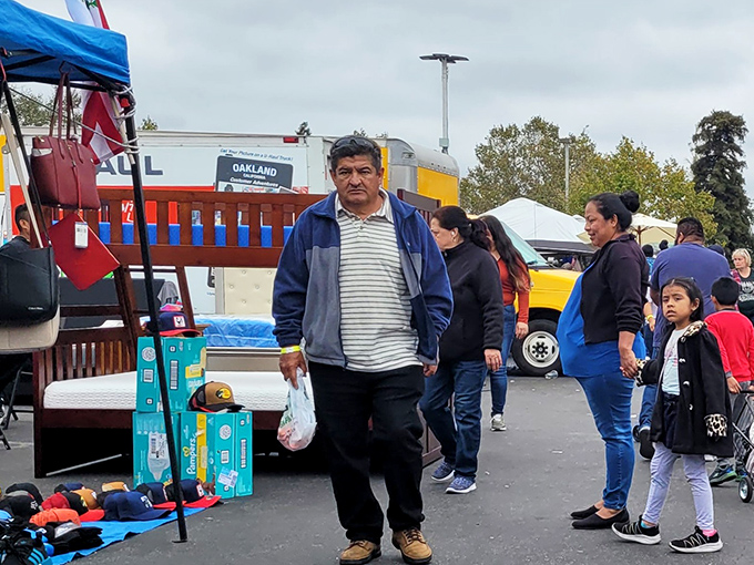 The weekend treasure hunt begins! Shoppers navigate the colorful maze of canopies at Oakland's beloved bargain bazaar, where one person's castoffs become another's prized finds.