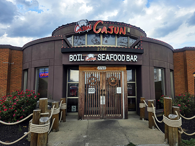 The unmistakable entrance to Cajun Boil Bar, where that giant crab logo practically winks at you, promising seafood treasures within.