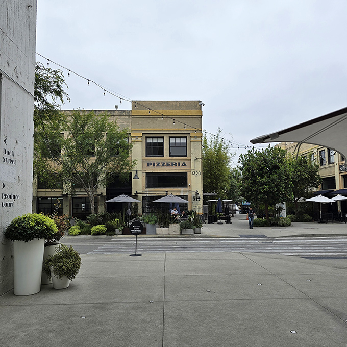 The unassuming exterior of Pizzeria Bianco stands like a culinary lighthouse in Row DTLA, beckoning pizza pilgrims with its simple "PIZZERIA" signage and string lights.