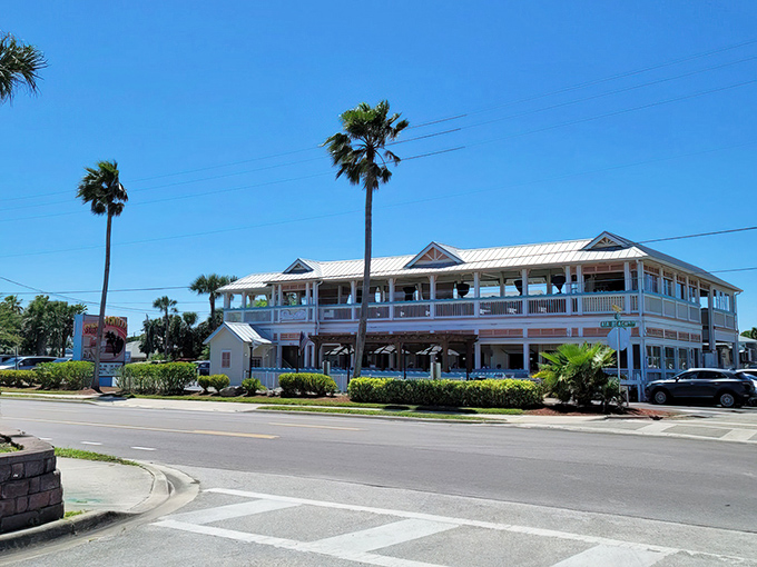 The classic Florida beach architecture of Sunset Grille stands proudly along A1A, its pale blue exterior and wraparound porches beckoning hungry travelers like a coastal mirage.