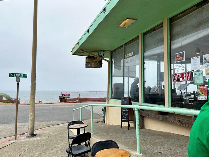 The mint-green facade of Chit Chat Cafe stands like a sentry at ocean's edge, where breakfast and breathtaking views collide in perfect harmony.