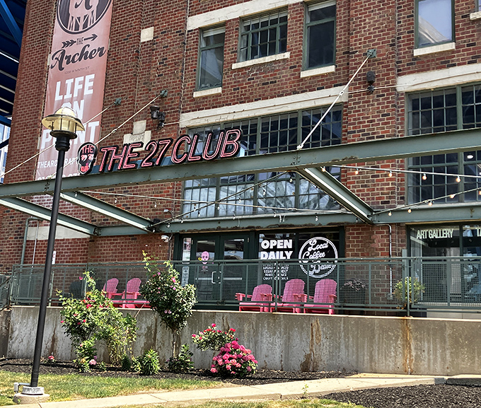 The 27 Club's striking brick exterior and neon signage stands as a love letter to rock history, while pink chairs promise comfort for the living.