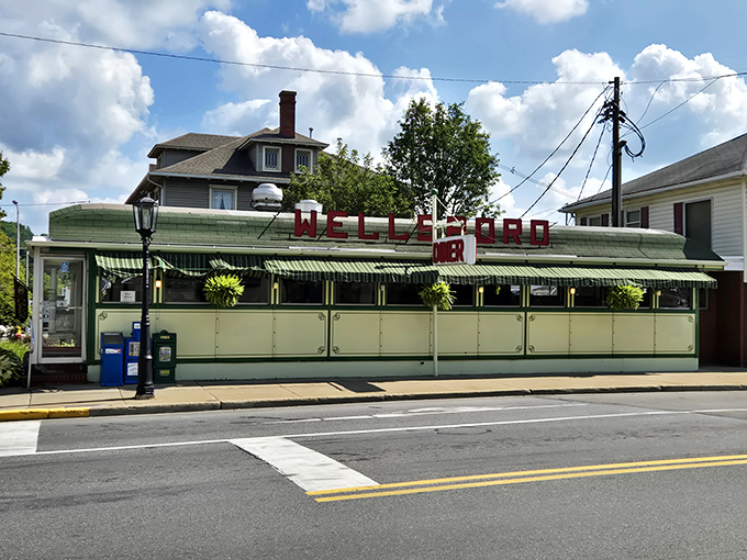 The iconic green exterior of Wellsboro Diner stands like a time capsule on Main Street, beckoning hungry travelers with its vintage charm and nostalgic appeal.