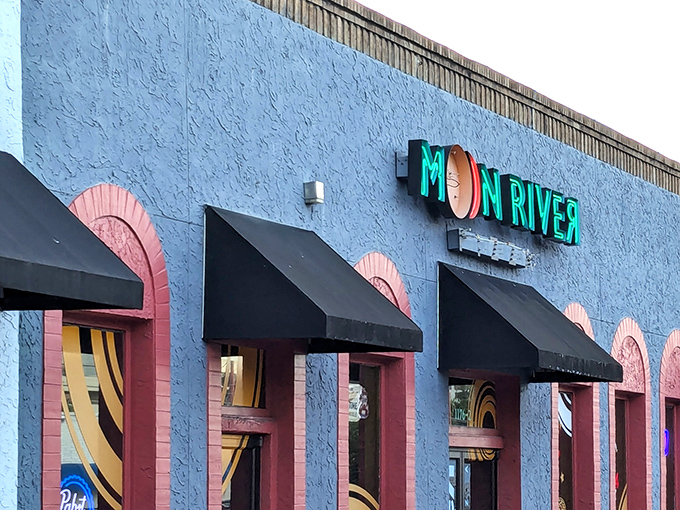 The blue exterior with vibrant neon signage announces you've arrived somewhere special. Moon River's façade promises a colorful pizza adventure inside.