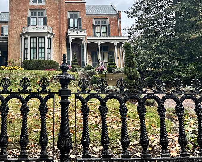 The grand entrance to The Castle beckons through ornate iron fencing, promising Victorian splendor behind those brick walls. History never looked so inviting!