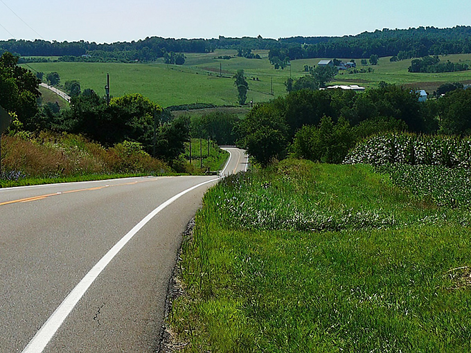 Where time slows down: A classic Amish buggy rolls past a quintessential red barn, offering a glimpse into the simpler rhythms of Amish Country.