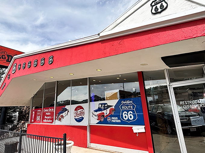 The vibrant red exterior of Goldies Route 66 Diner stands as a beacon to hungry travelers, promising a journey back to simpler times.