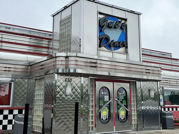 The gleaming stainless steel exterior of Gus's Diner stands like a time capsule from the 1950s, beckoning hungry travelers with its retro charm and nostalgic appeal.