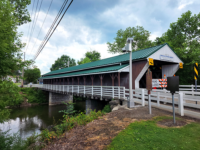 The Historic Newton Falls Covered Bridge stands like a time machine disguised as architecture, its white railings and green roof beckoning travelers into Ohio's past.