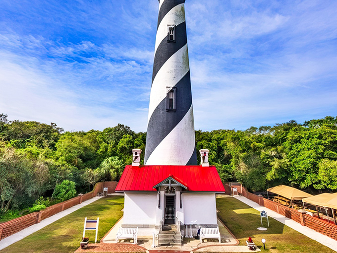 The iconic black and white spiral of St. Augustine Lighthouse stands tall against a perfect Florida sky, like a maritime barber pole guiding ships home.
