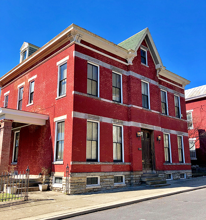 The crimson brick exterior of Sedamsville Rectory stands defiantly against the blue sky, like a Victorian-era movie set waiting for its ghost story to unfold.