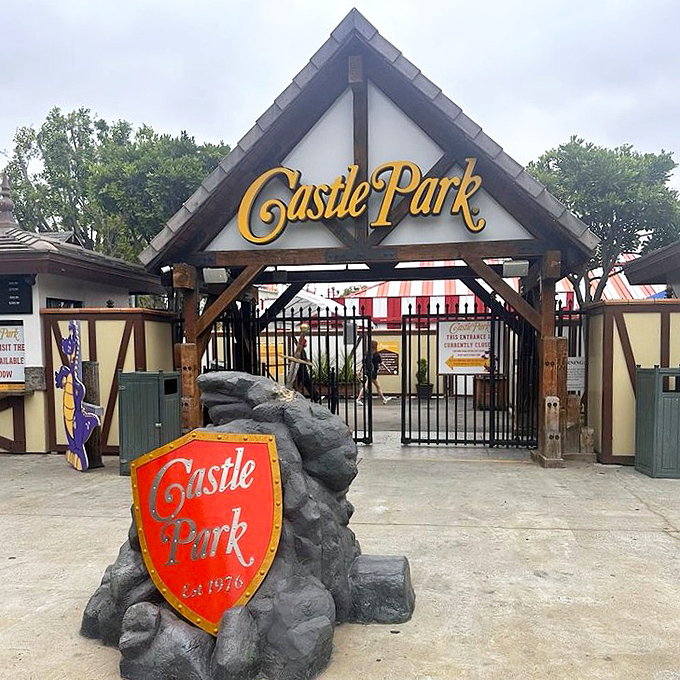 The welcoming entrance to Castle Park beckons with medieval charm and the promise of nostalgic fun. That red shield has seen decades of excited families pass through.