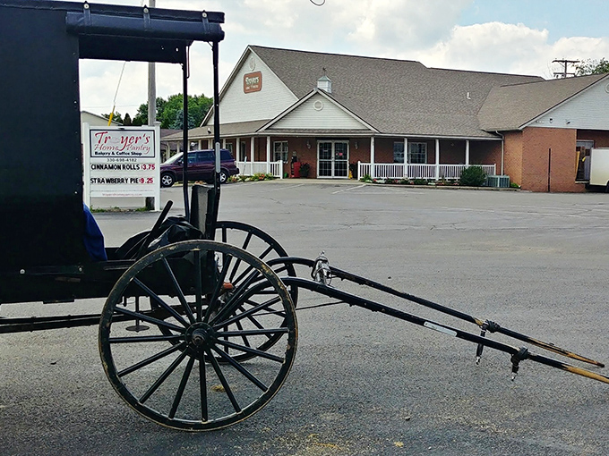 The welcoming facade of Troyer's Home Pantry stands ready for visitors, with the classic Amish buggy parked outside reminding you this is the real deal.
