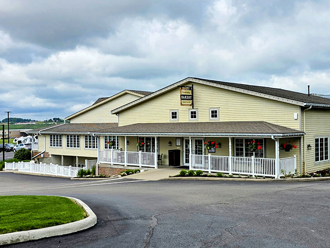 The welcoming yellow exterior of Dutch Valley Restaurant stands like a beacon of comfort food in Sugarcreek's rolling countryside. Those hanging flower baskets aren't just for show!