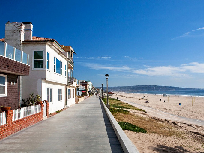 The Strand's pristine walkway invites you to stroll alongside million-dollar homes while contemplating why you didn't buy beachfront property in 1975.
