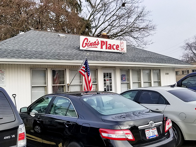 The unassuming white exterior of Gina's Place stands like a breakfast beacon in Fairview Park, complete with American flag and that classic red sign promising good things inside.