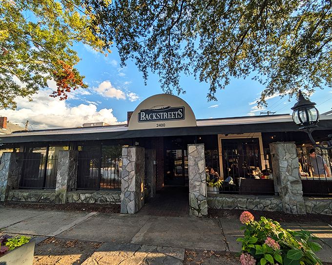 Stone pillars and lush greenery welcome you to Backstreets Grill, where Columbia's culinary treasures hide in plain sight under South Carolina's blue skies.