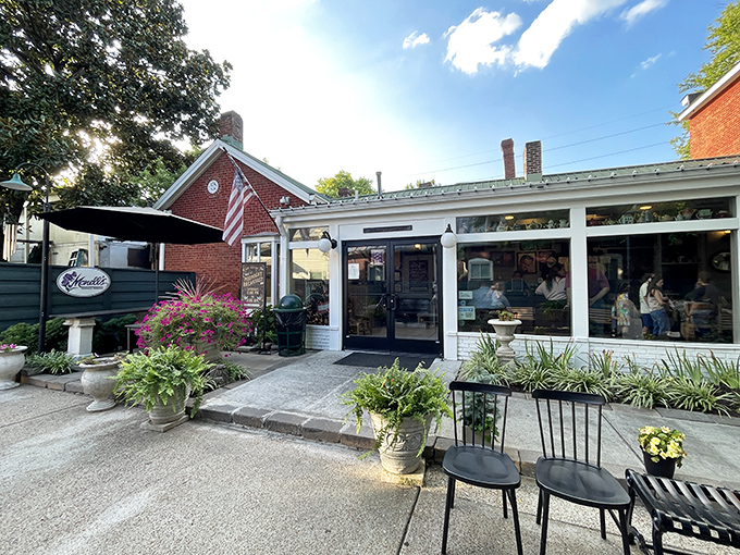 The historic red brick exterior of Monell's welcomes hungry visitors with Southern charm, complete with a welcoming porch and lush greenery.