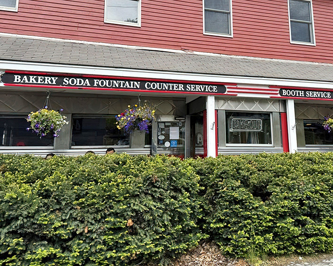 The classic red exterior of Four Aces Diner stands like a time capsule in West Lebanon, promising comfort food that predates your smartphone addiction.