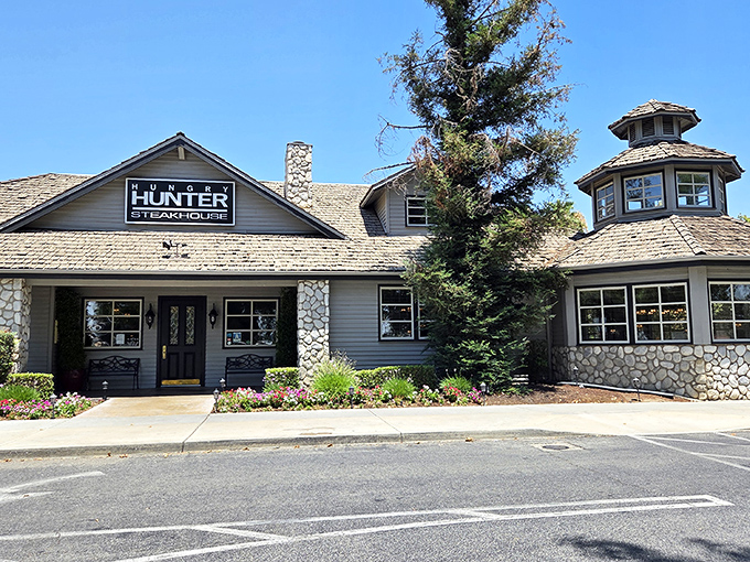 The rustic stone and timber exterior of Hungry Hunter Steakhouse stands like a welcoming mountain lodge, promising carnivorous delights within its cozy walls.