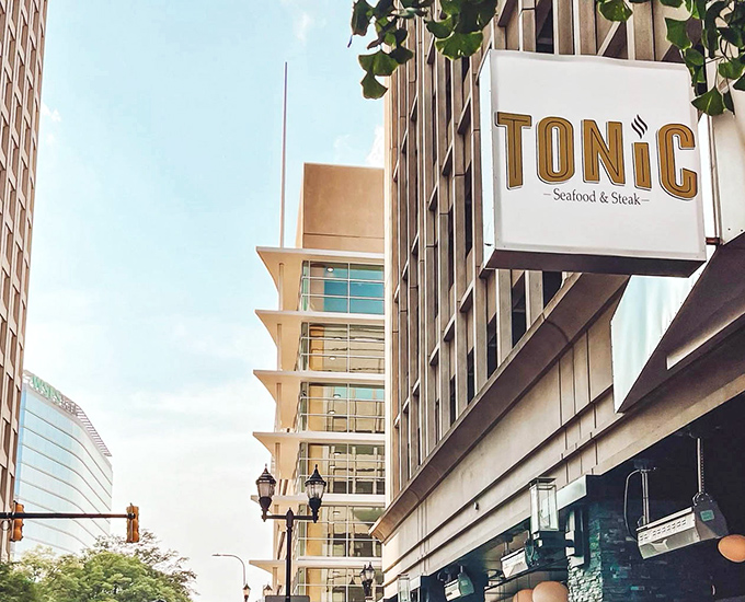 The golden "TONIC" sign beckons from downtown Wilmington like a culinary lighthouse, promising safe harbor for hungry souls navigating the urban landscape.