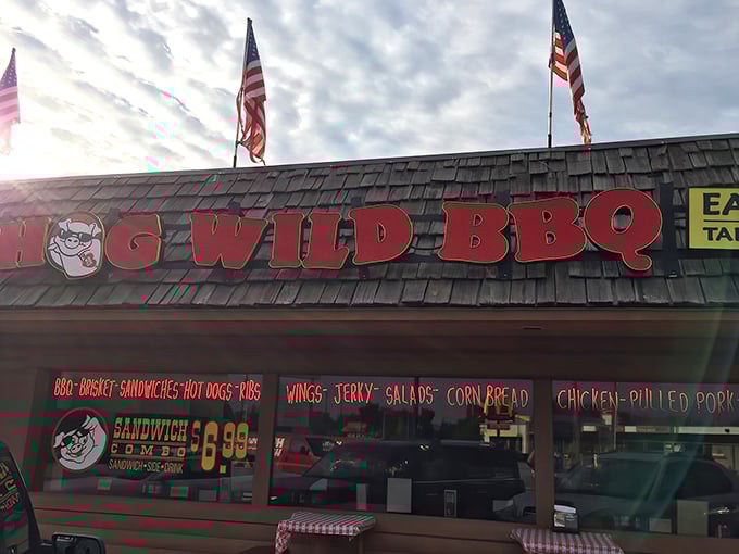 Hog Wild BBQ's rustic exterior promises smoky delights beneath American flags&mdash;a carnivore's paradise hiding in plain sight in Holland.