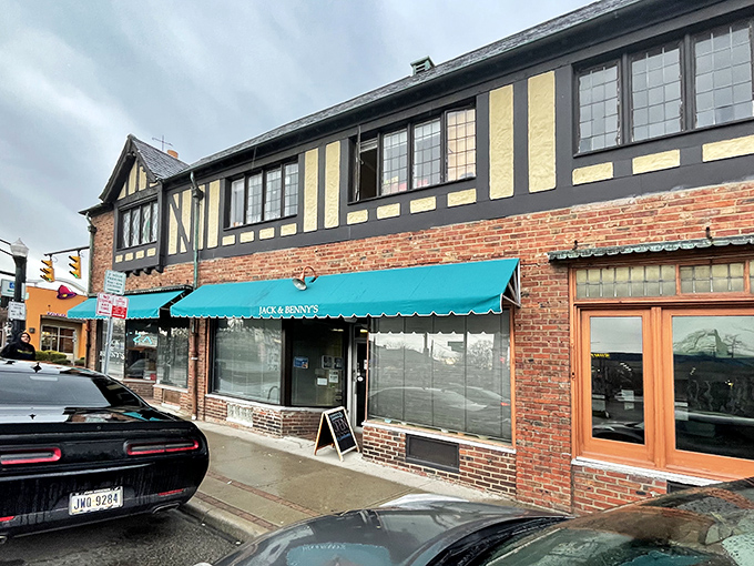 The Tudor-style brick exterior of Jack & Benny's, with its distinctive teal awning, promises comfort food treasures within. No fancy valet parking needed.