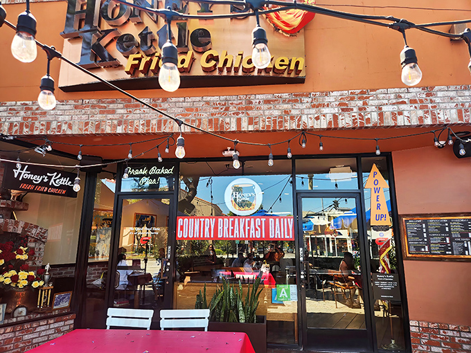 The warm terracotta exterior of Honey's Kettle beckons with twinkling string lights and a promise of "Country Breakfast Daily" that's impossible to resist.