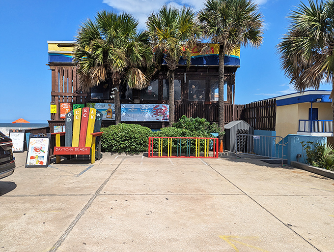 The colorful exterior of Ocean Deck beckons like a tropical mirage, palm trees swaying as if they're dancing to the reggae soundtrack inside.
