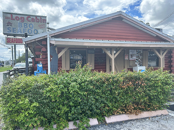 Like finding a wooden treasure chest filled with smoked meats instead of gold doubloons, The Log Cabin BBQ's exterior promises rustic charm and culinary riches within.
