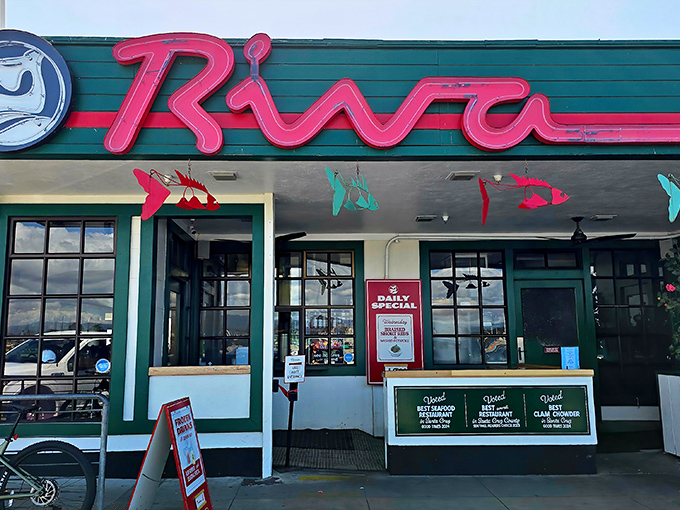 The iconic neon sign beckons like a lighthouse for hungry souls&mdash;Riva's vibrant red script promising seafood salvation on Santa Cruz Wharf.
