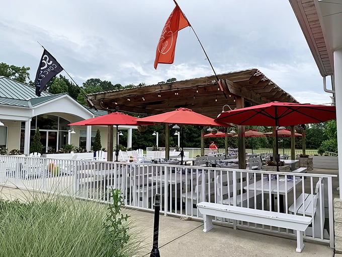 The welcoming exterior of Northeast Seafood Kitchen beckons with its crisp white facade and inviting outdoor seating area. Those red umbrellas practically whisper, "Come sit a while."