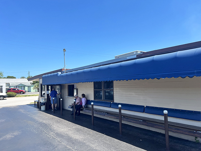The blue awning welcomes hungry patrons who know that the best seafood spots often come with a wait. Worth every minute, trust me.