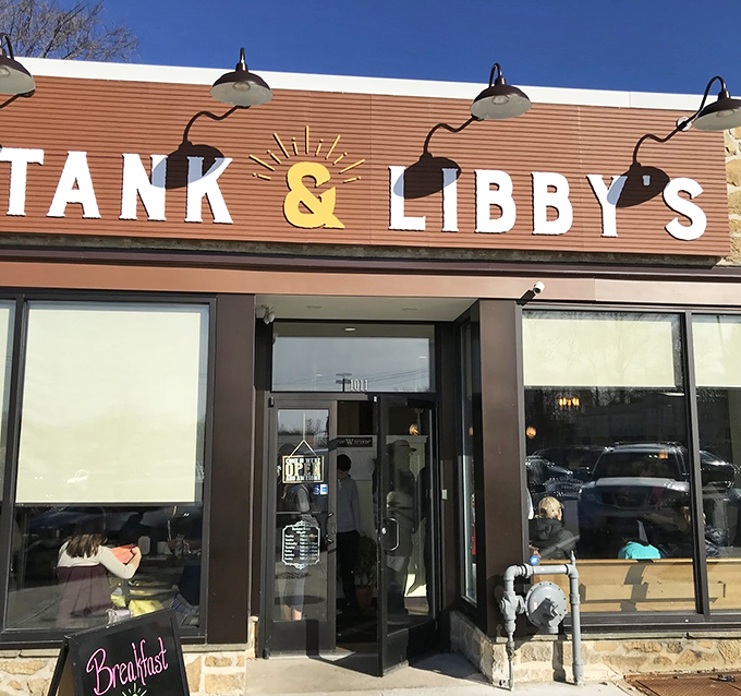 The sunshine-yellow ampersand between "TANK & LIBBY'S" isn't just cheerful decoration&mdash;it's a promise that something special awaits behind those bamboo-shaded windows.