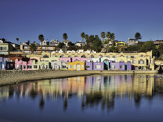 Capitola's famous rainbow-hued Venetian Court apartments create the ultimate California postcard moment, their colors dancing across the lagoon's surface at sunset.