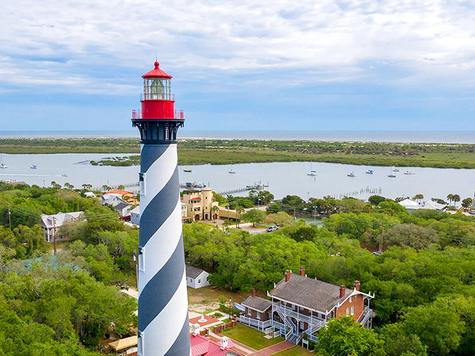 The iconic black and white spiral of St. Augustine Lighthouse stands sentinel over Anastasia Island, a postcard-perfect scene that's been guiding mariners since 1874.