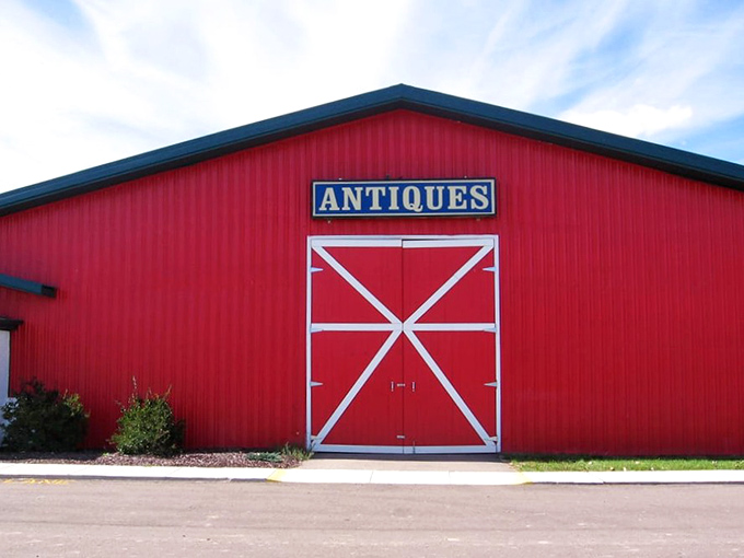 The iconic red barn exterior of Livingston Antique Outlet stands like a beacon for treasure hunters, promising adventures in vintage wonderland behind those classic white-trimmed doors.