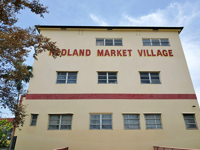 The cream-colored facade of Redland Market Village stands like a bargain hunter's lighthouse, beckoning shoppers with its distinctive red trim and promise of treasures within.