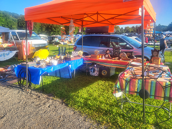 A treasure hunter's paradise under vibrant orange canopies. This vendor's eclectic mix of glassware and decorative items proves one person's castoff is another's centerpiece.