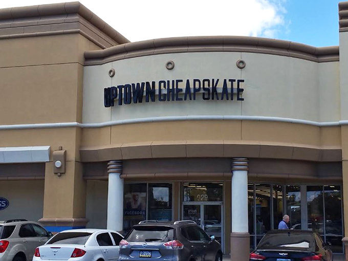 The beige storefront of Uptown Cheapskate stands ready to welcome bargain hunters with its clean lines and inviting entrance.